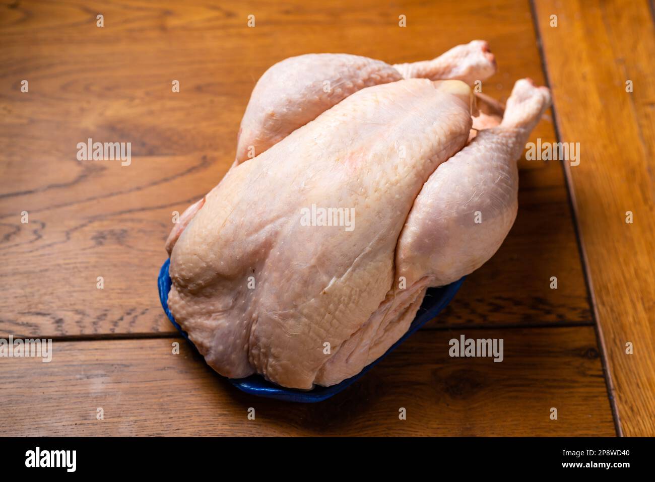 Raw whole chicken on wooden background. Chicken carcass from store ...