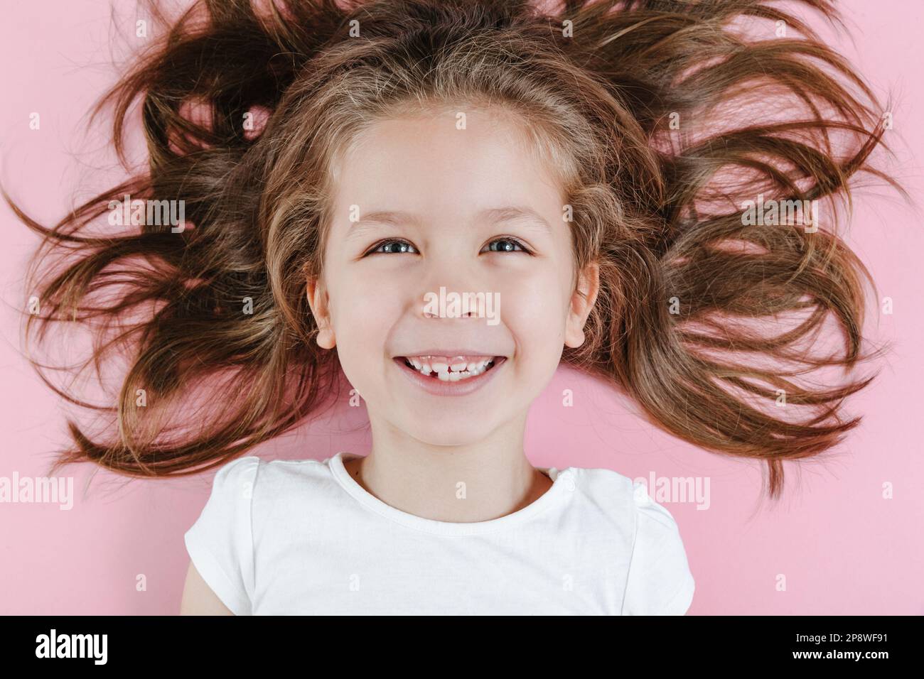 Happy smiling child portrait on the pink background. Little todler ...