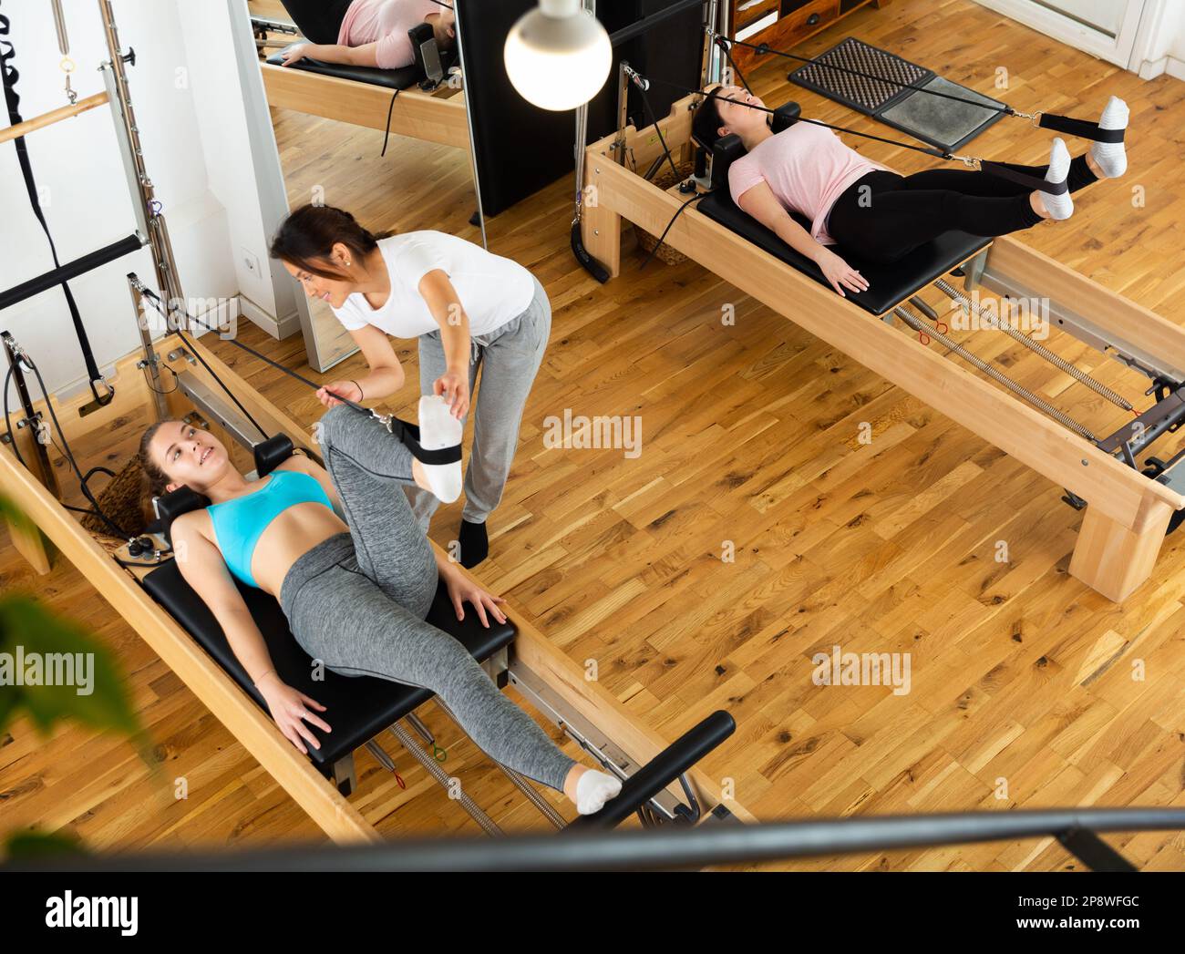 Pilates instructor training women at gym Stock Photo - Alamy