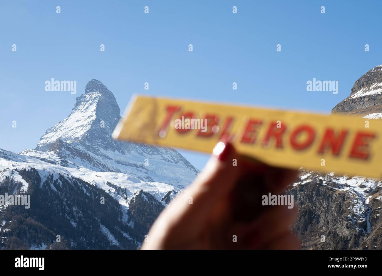 View of the Matterhorn with a Toblerone chocolate bar held in front ...