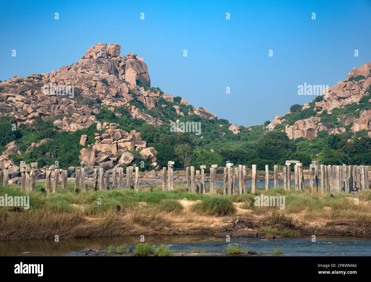 Stone pillars of the abandoned old bridge of Tungabhadra River, Hampi, India. Hampi, the capital ...