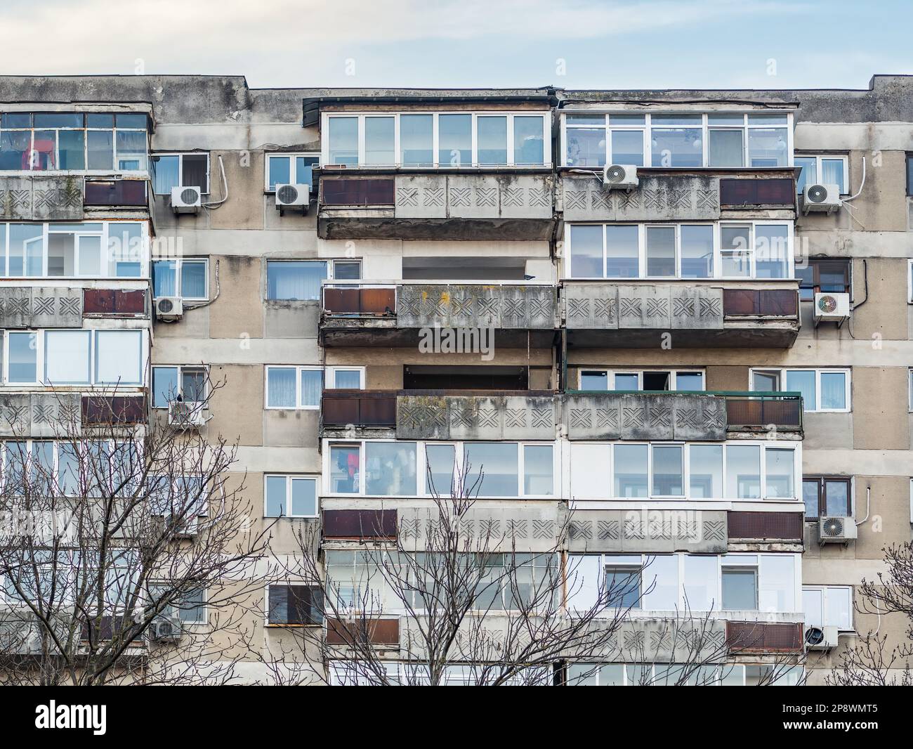 Worn out apartment building from the communist era against blue sky in ...