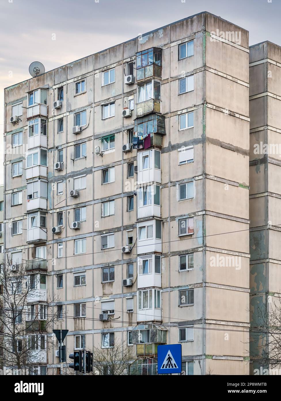 Worn out apartment building from the communist era against blue sky in ...