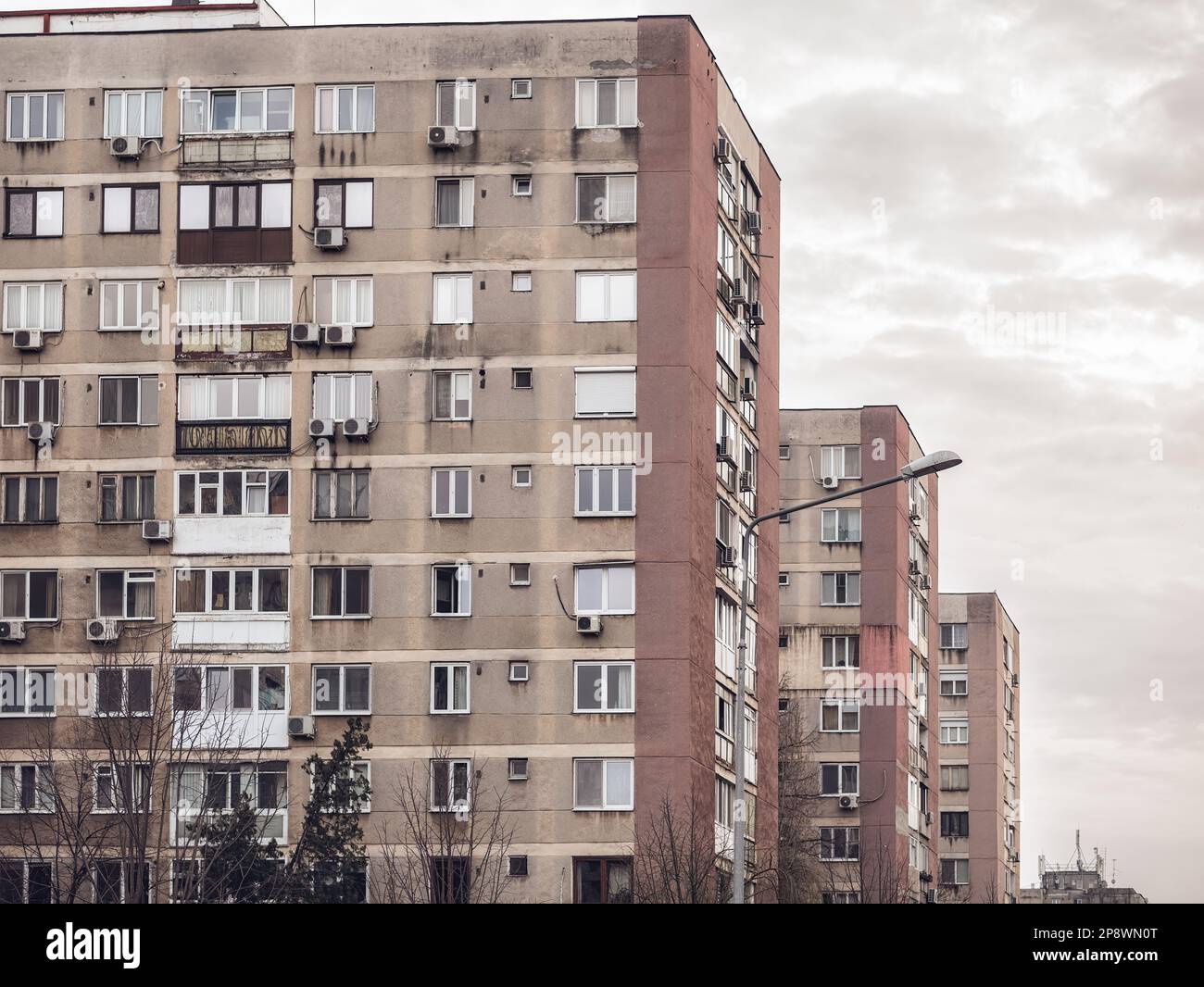 Worn out apartment building from the communist era against blue sky in ...