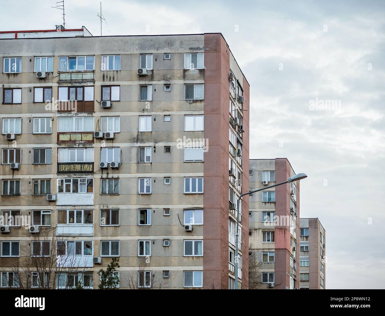 Worn out apartment building from the communist era against blue sky in ...