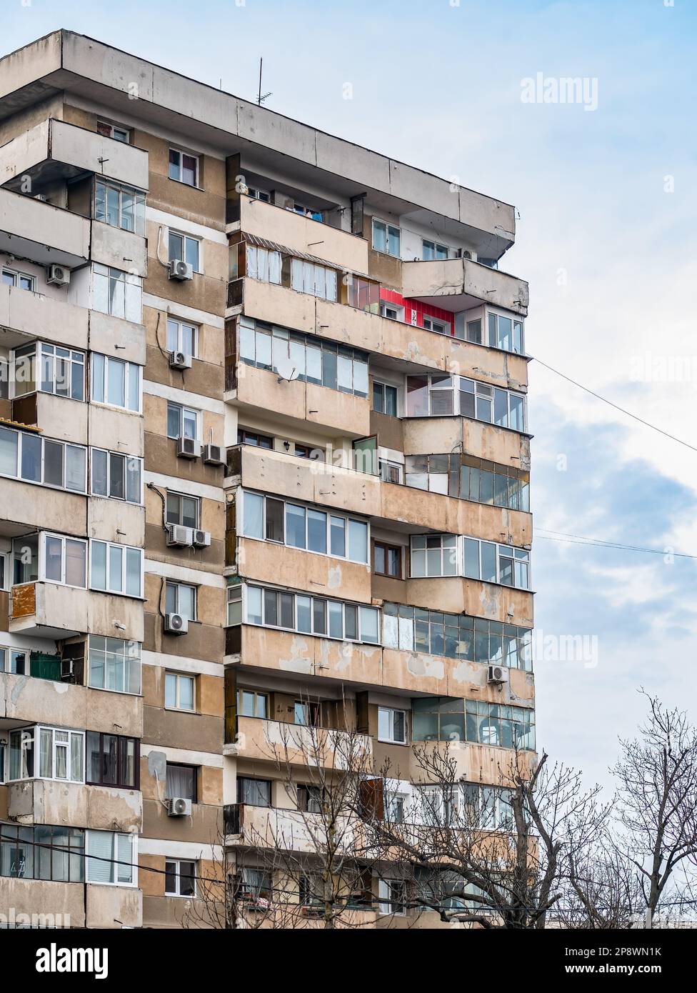 Worn out apartment building from the communist era against blue sky in ...