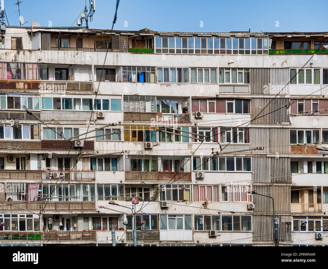Worn out apartment building from the communist era against blue sky in ...