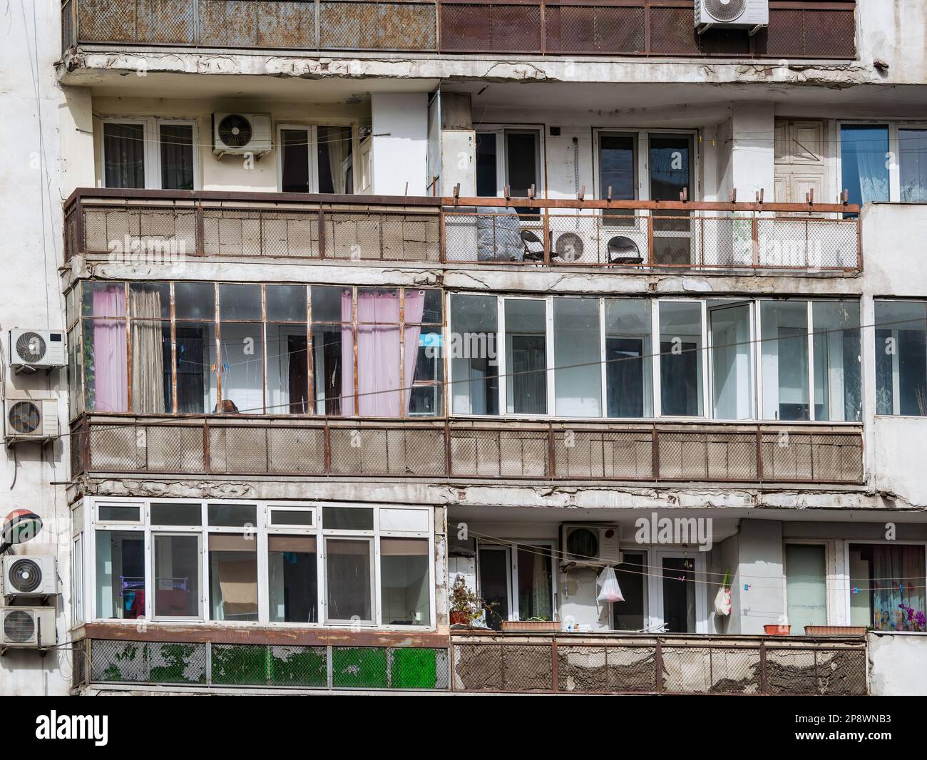 Worn out apartment building from the communist era against blue sky in ...