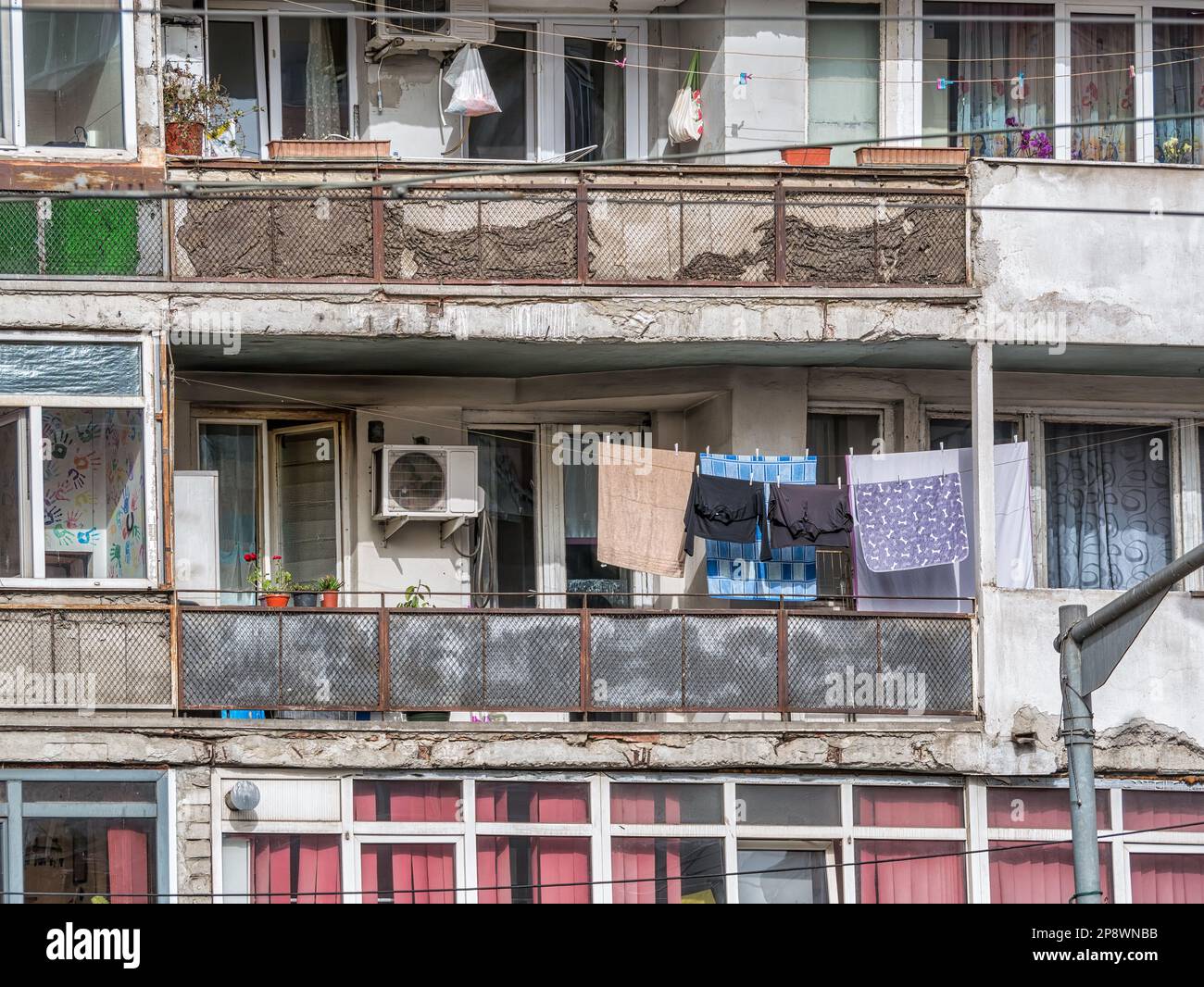 Worn out apartment building from the communist era against blue sky in ...