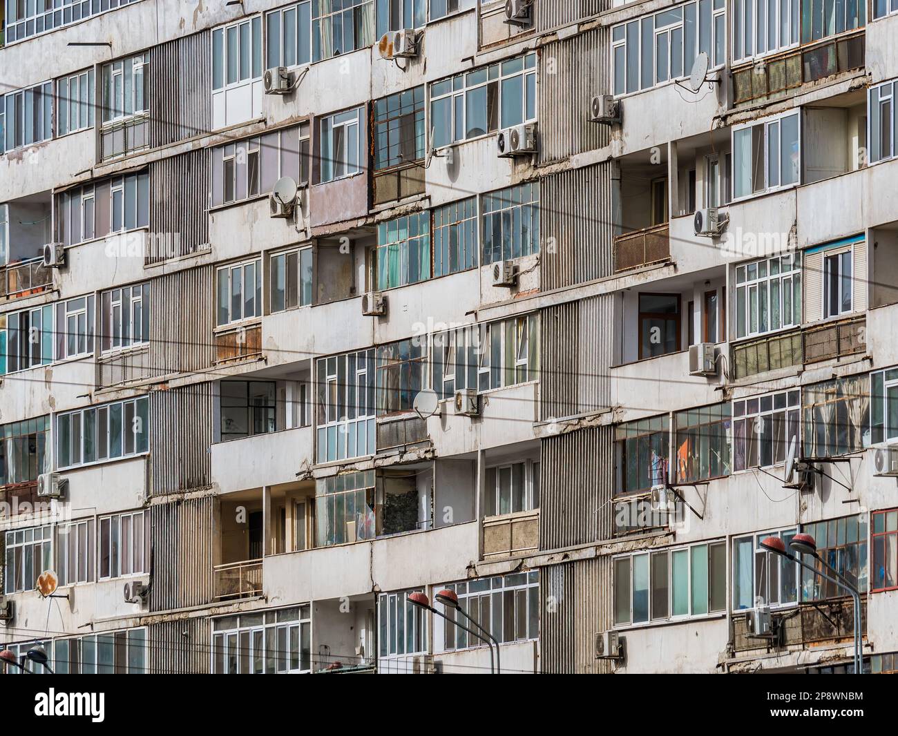 Worn out apartment building from the communist era against blue sky in ...