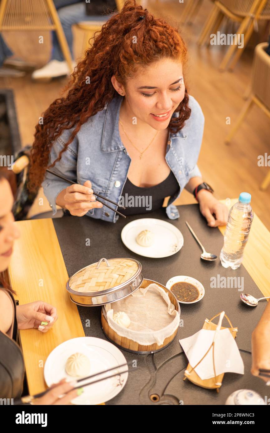 table served with dumplings, plates and sauce, sharing food in asian ...