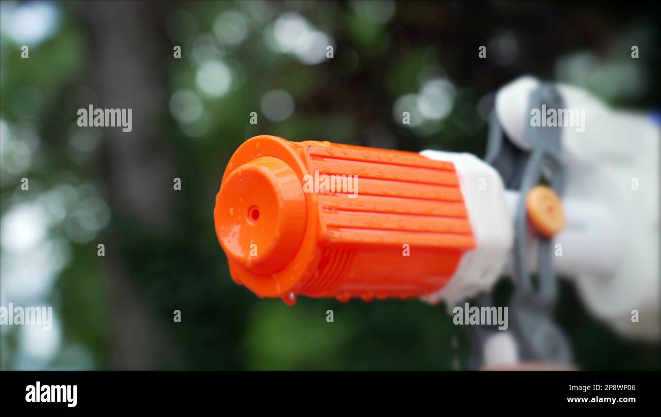 Water gun spraying water close up outside. Plastic Toy Weapon splashing ...