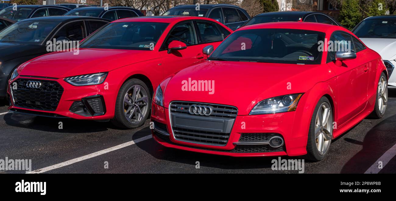 Two new, red Audi vehicles, a sedan and coupe for sale at a dealership ...
