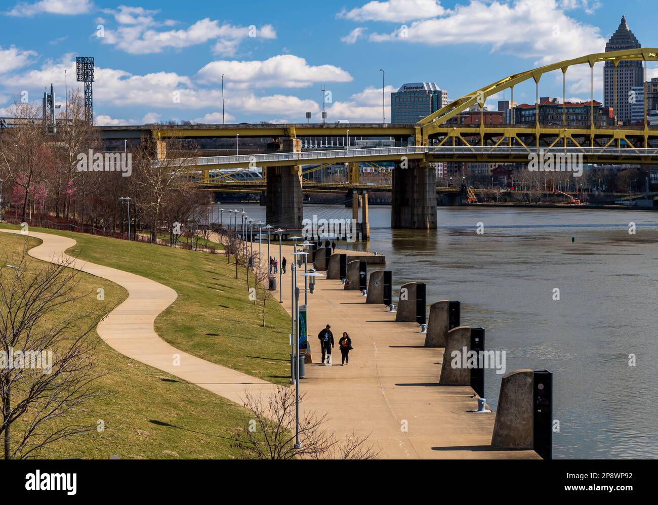 People walking along the river walk next to the Allegheny River on the ...