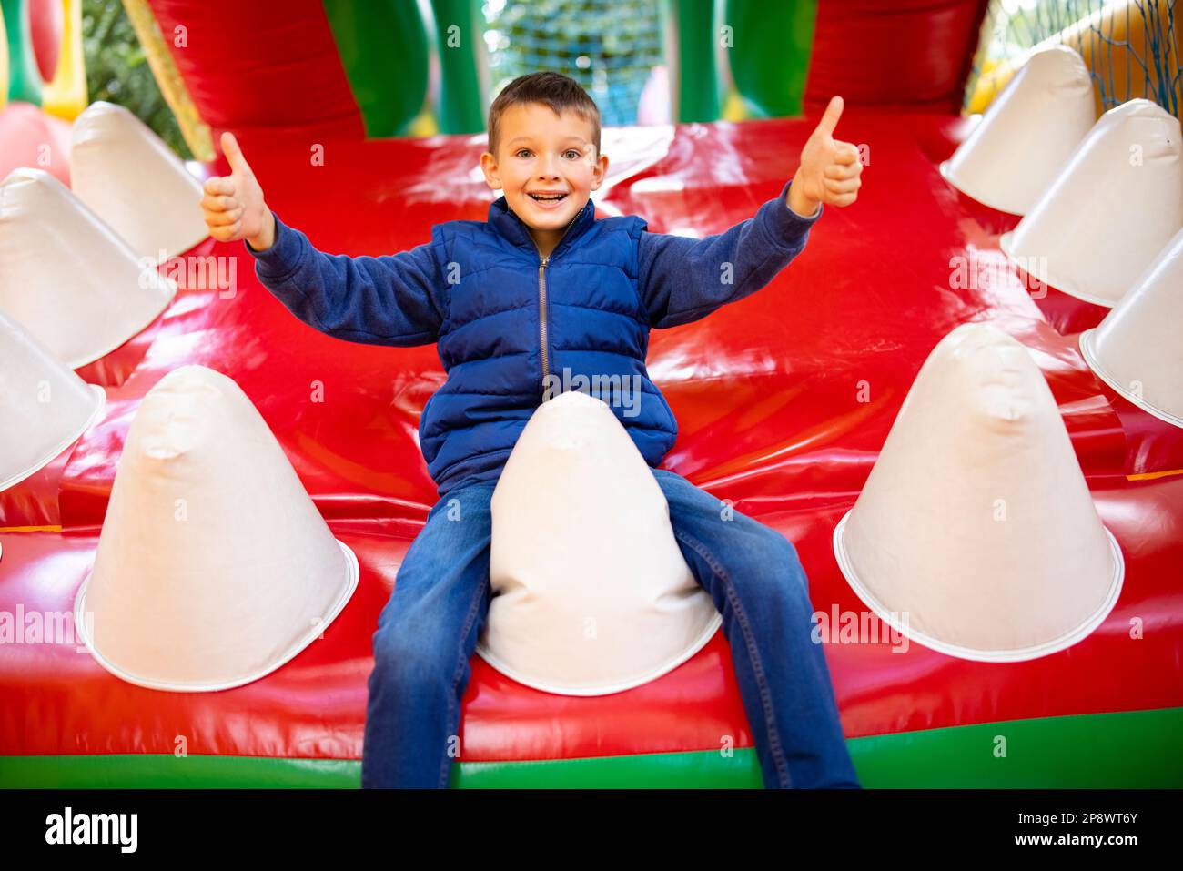 Happy boy having a lots of fun on a colorful inflate castle Stock Photo ...
