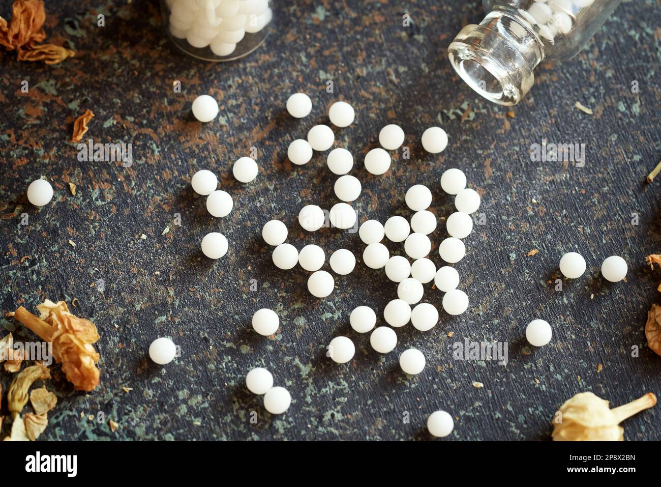 Homeopathic globules spilled on a table, top view. Alternative medicine ...