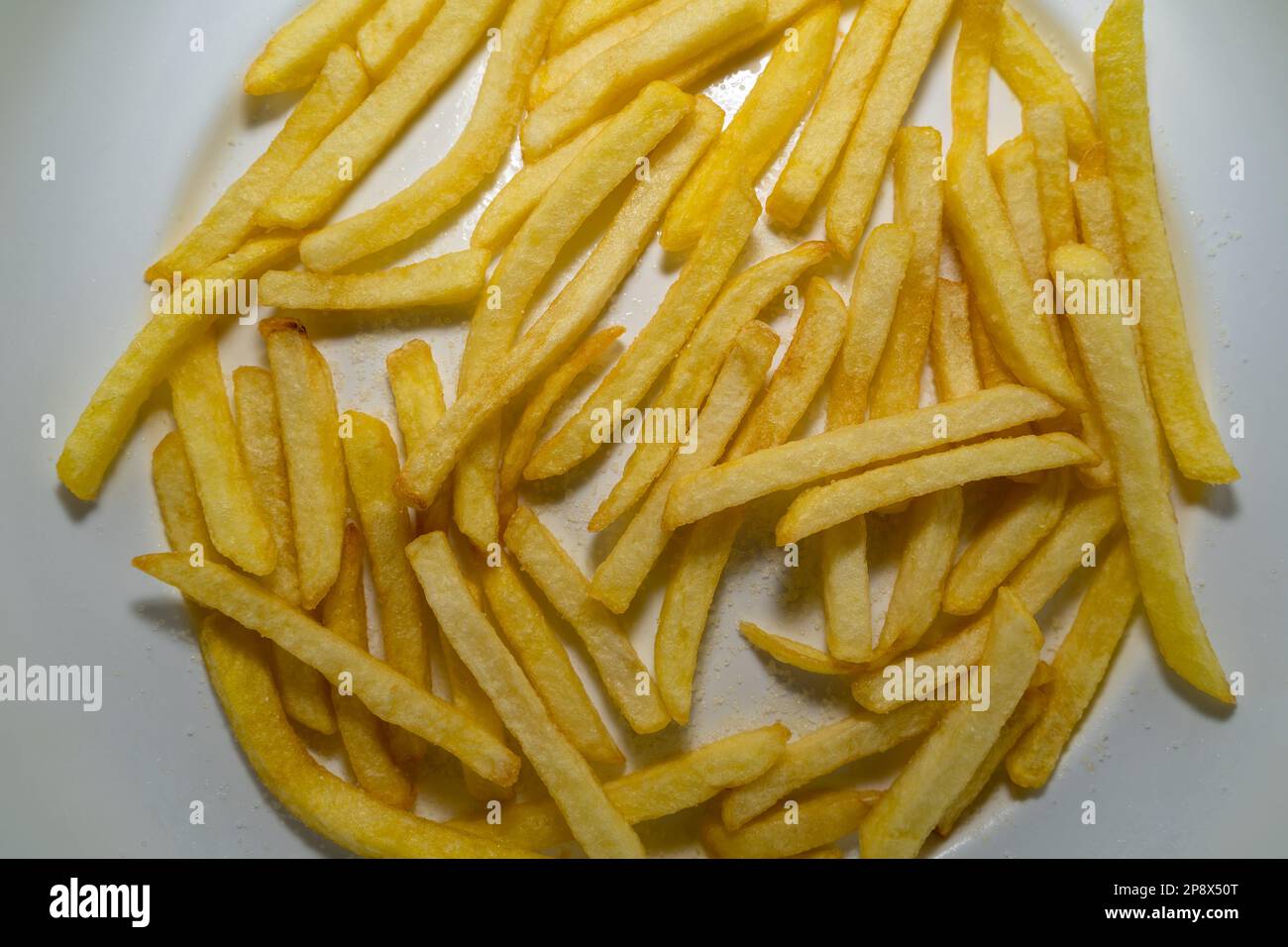 Fried and salted fries on a white plate Stock Photo - Alamy