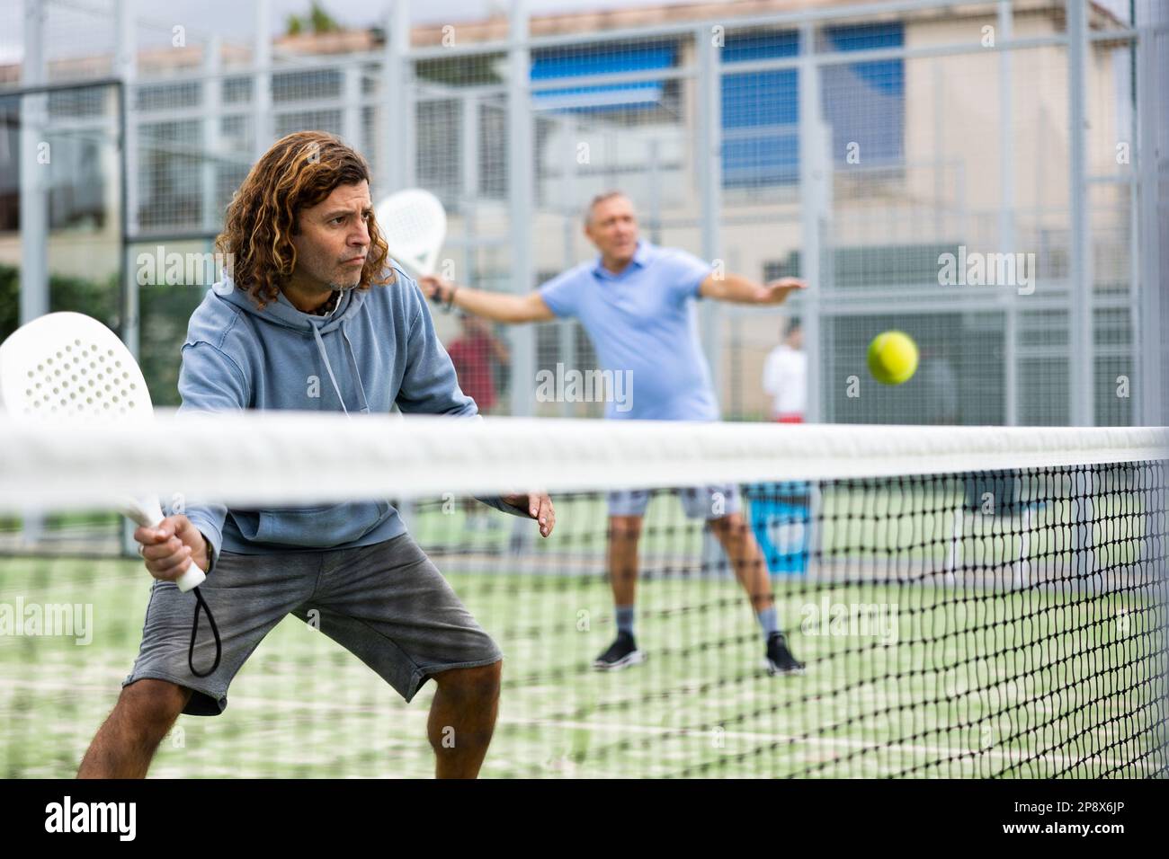 Serious middle-aged Latin man tennis player playing padel during ...