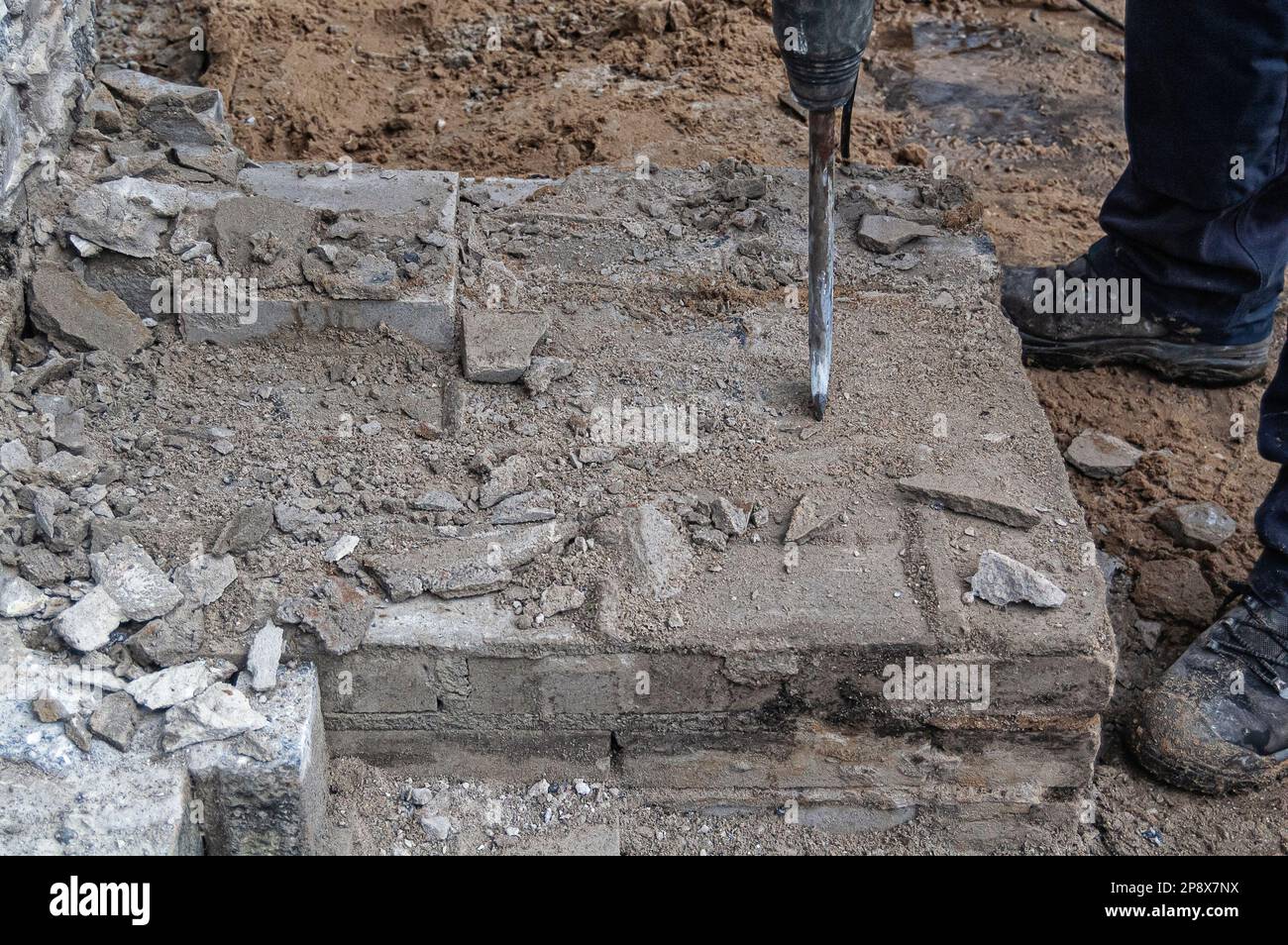 earthworker is busy with a pneumatic demolition hammer breaking a ...