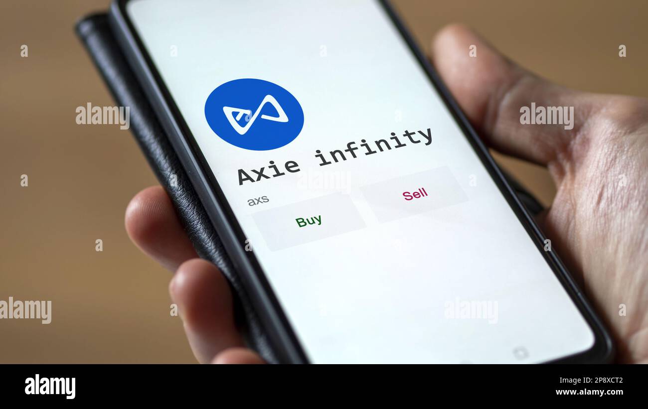 An investor's analyzing the Axie Infinity AXS coin on screen. A phone ...