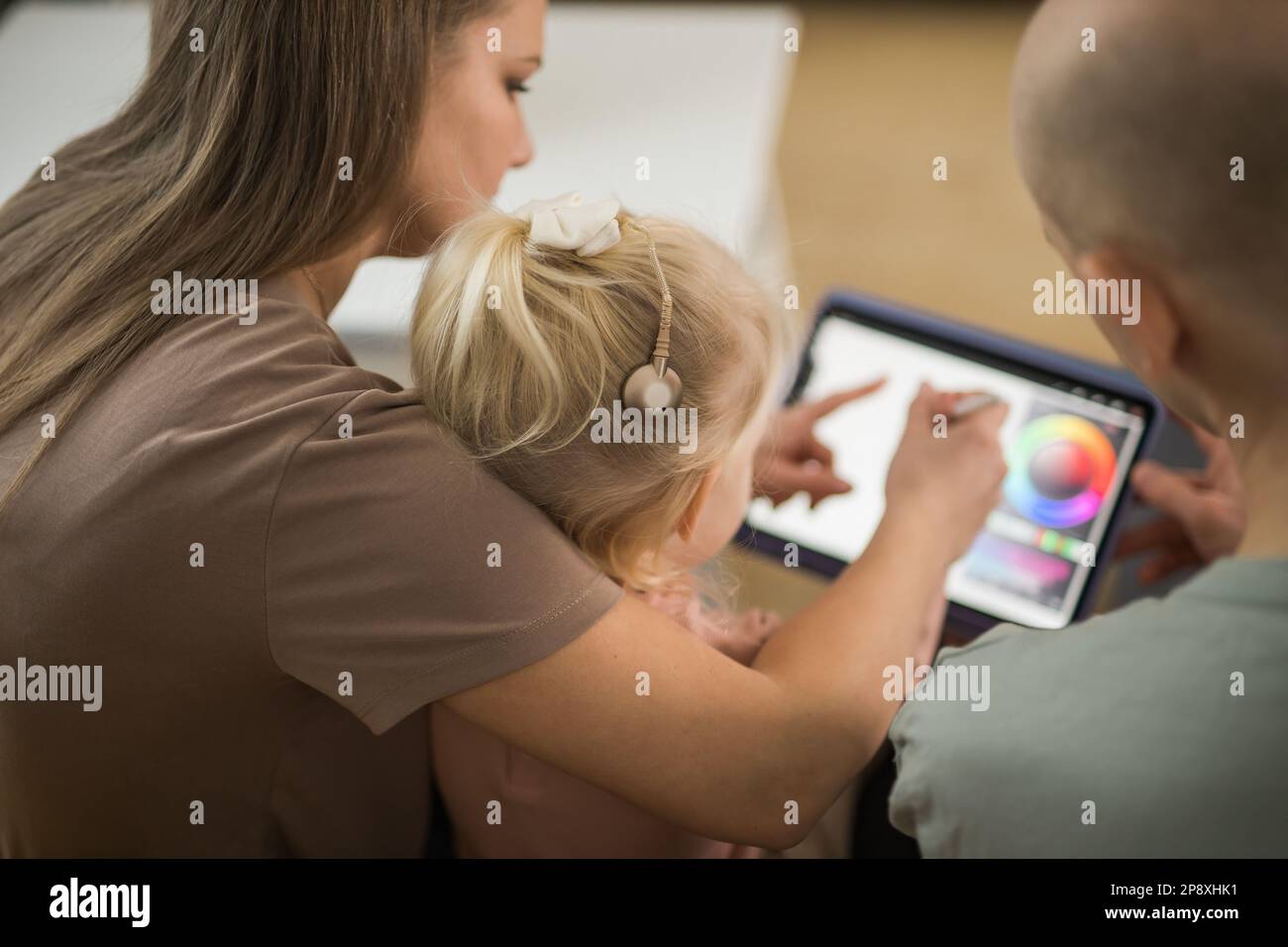 Deaf child girl with cochlear implant studying to hear sounds and have ...