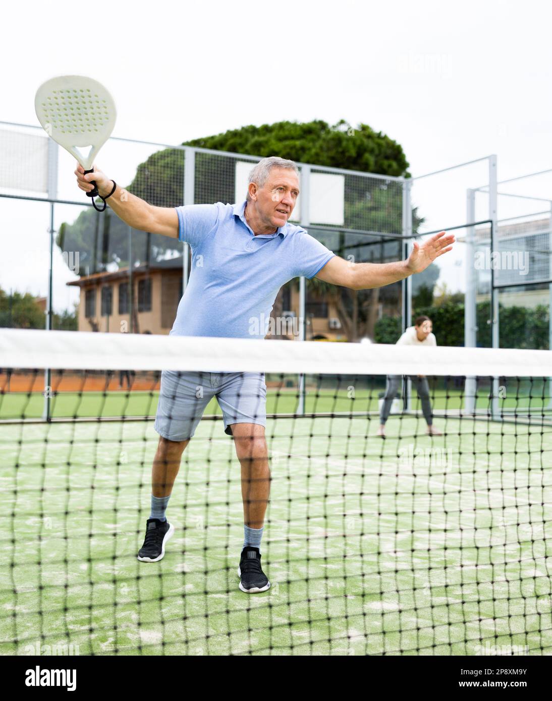 Sporty senior man playing padel on open tennis court Stock Photo - Alamy