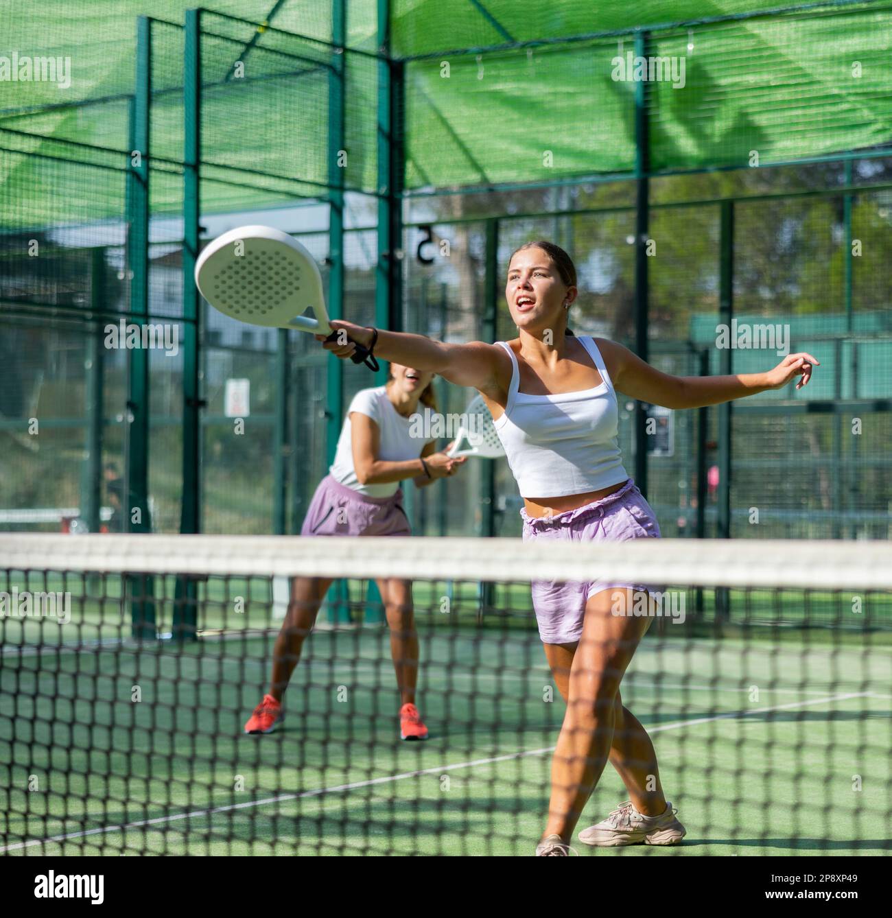Padel game - woman with partners plays on tennis court Stock Photo - Alamy