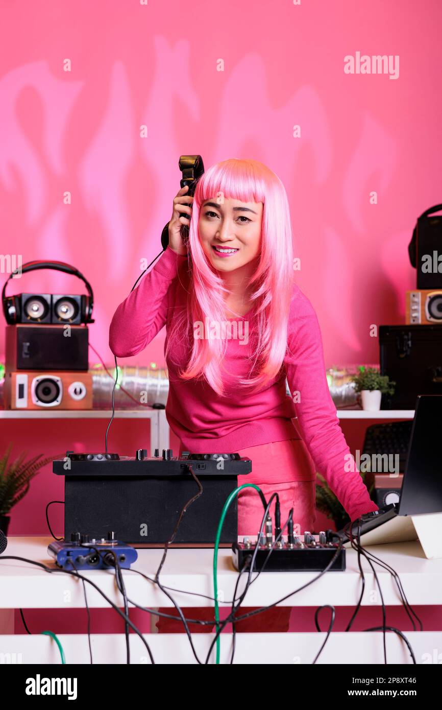 Asian performer dancing while playing techno music at professional ...