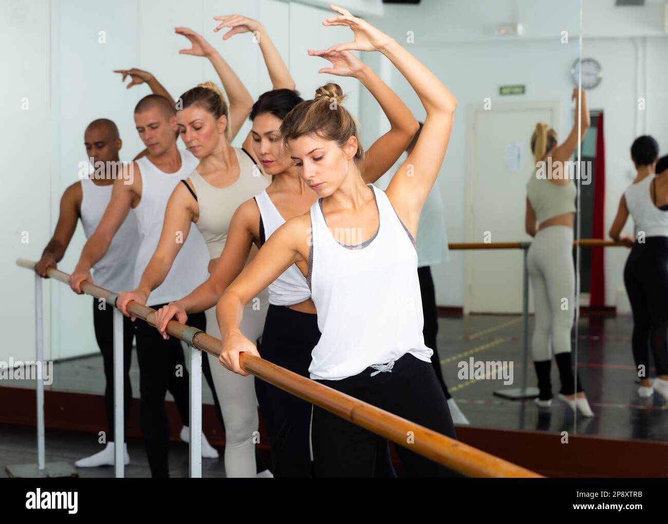 aduls people doing exercises on stretching ballet barre Stock Photo - Alamy