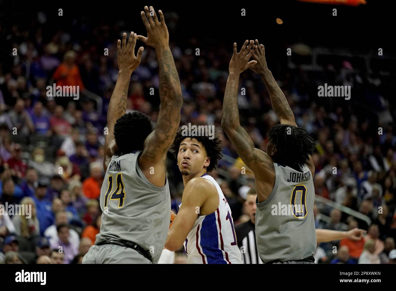Kansas forward Jalen Wilson, center, looks to pass under pressure from ...