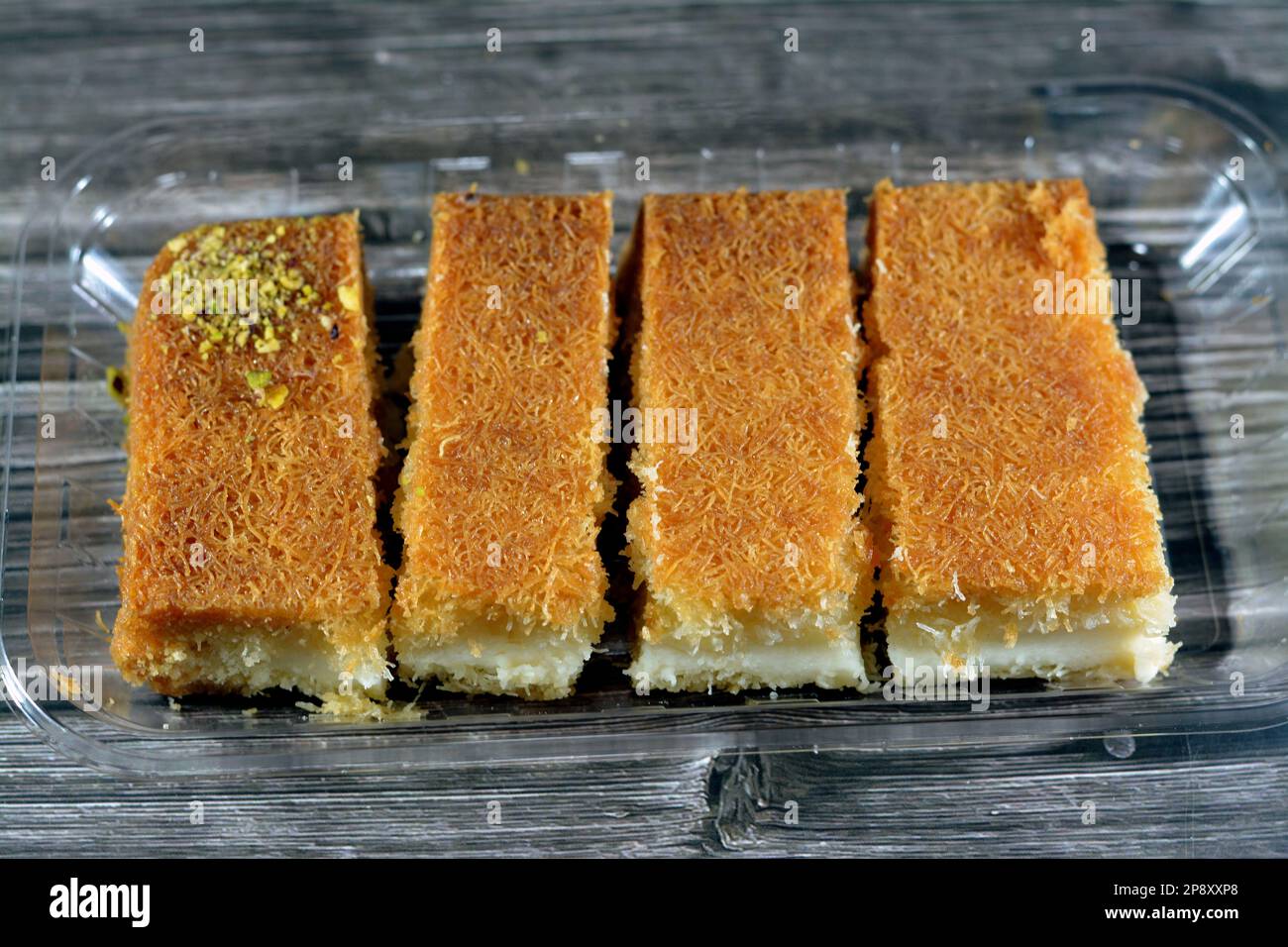 Konafa covered with nuts and stuffed with whipped cream and soaked with ...