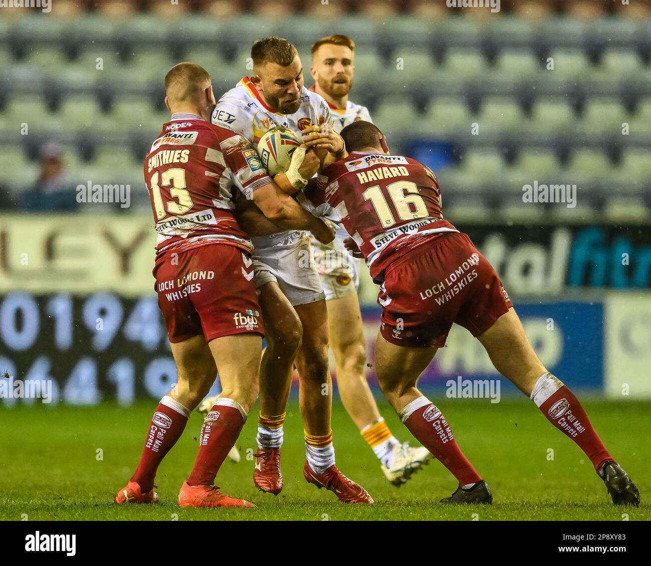 Mike McMeeken #8 of Catalans Dragons is tackled by Ethan Havard #16 and ...