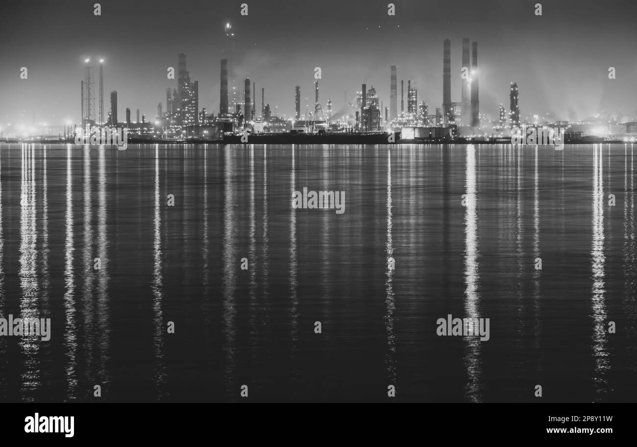 Oil refinery at night. Oil refinery lights reflecting to sea. Night ...