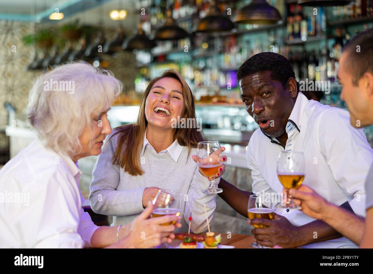 Diverse friends talking and laughing at a pub Stock Photo - Alamy