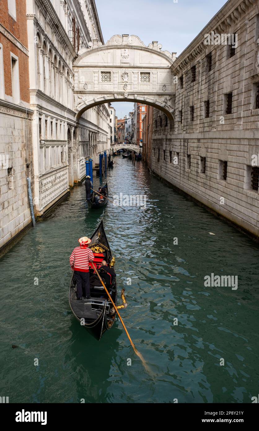Gondoliers paddle their gondolas under the Ponte dei Sospiri (Bridge of ...