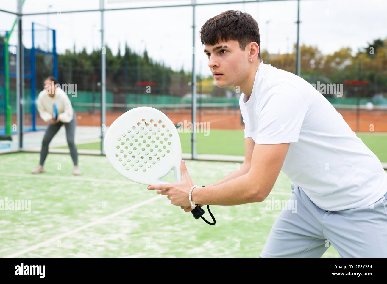 Guy hitting two handed backhand during paddle tennis match Stock Photo ...