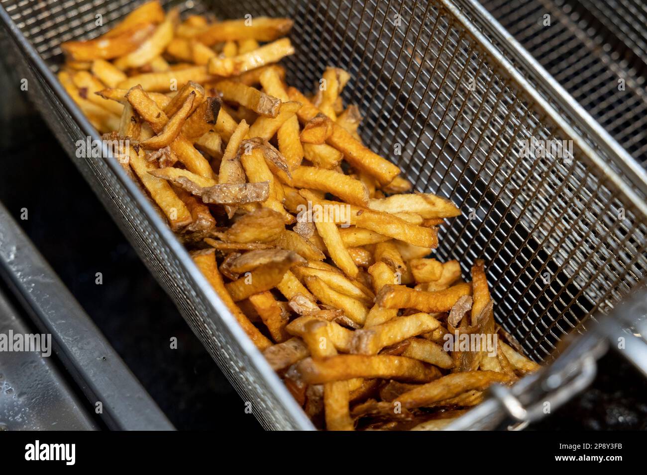 Fresh fries in a wire mesh deep-fryer basket Stock Photo - Alamy