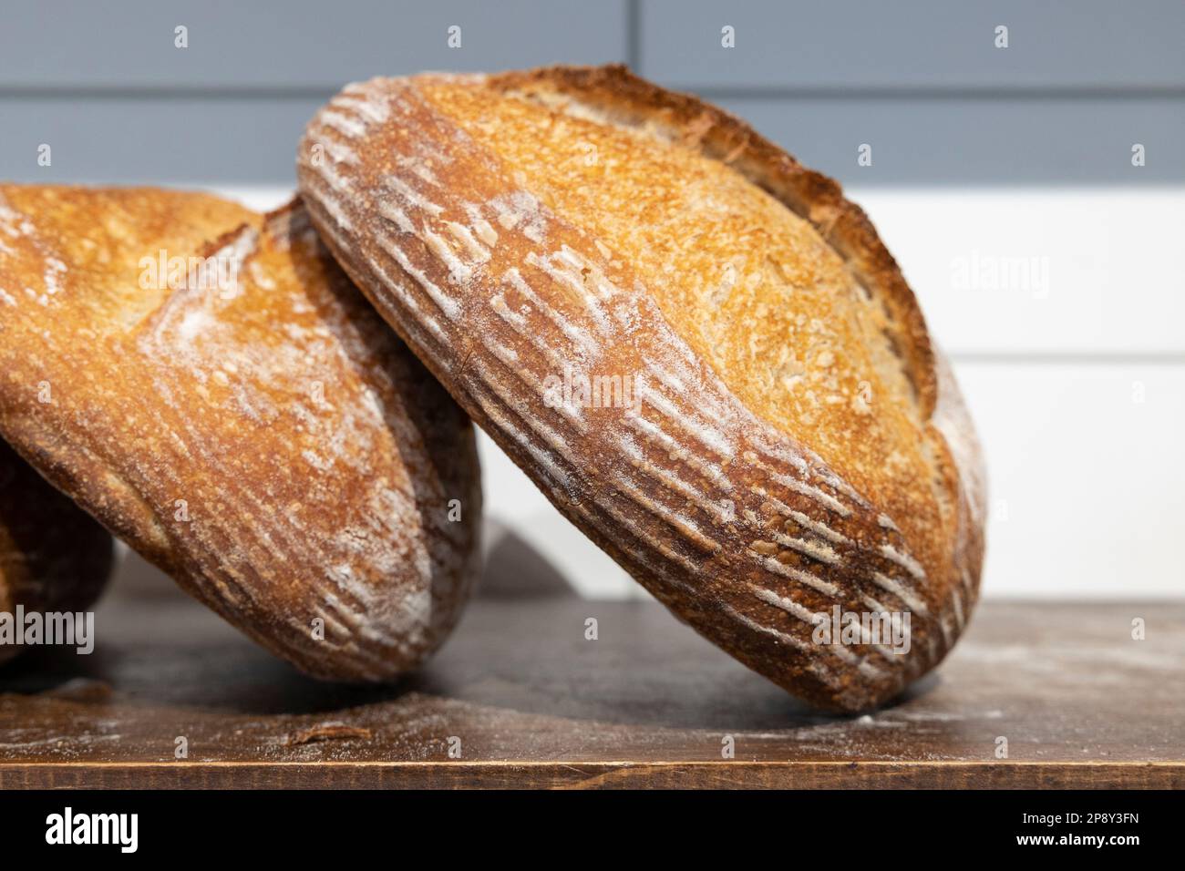 Fresh-baked loaves of artisan bread on a shelf in a bakery Stock Photo ...