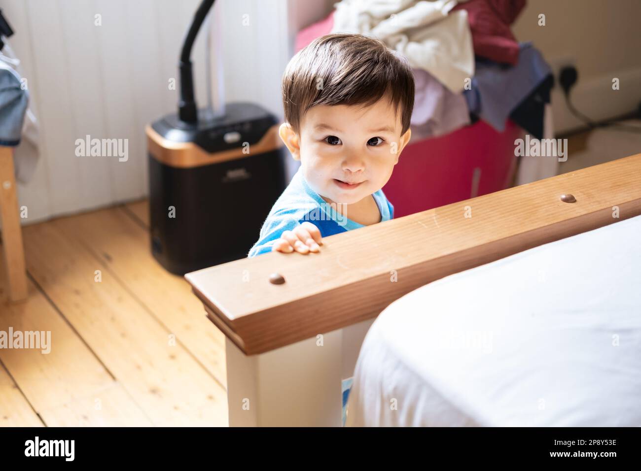 A mixed race Southeast Asian and Spanish infant wearing blue pajamas ...
