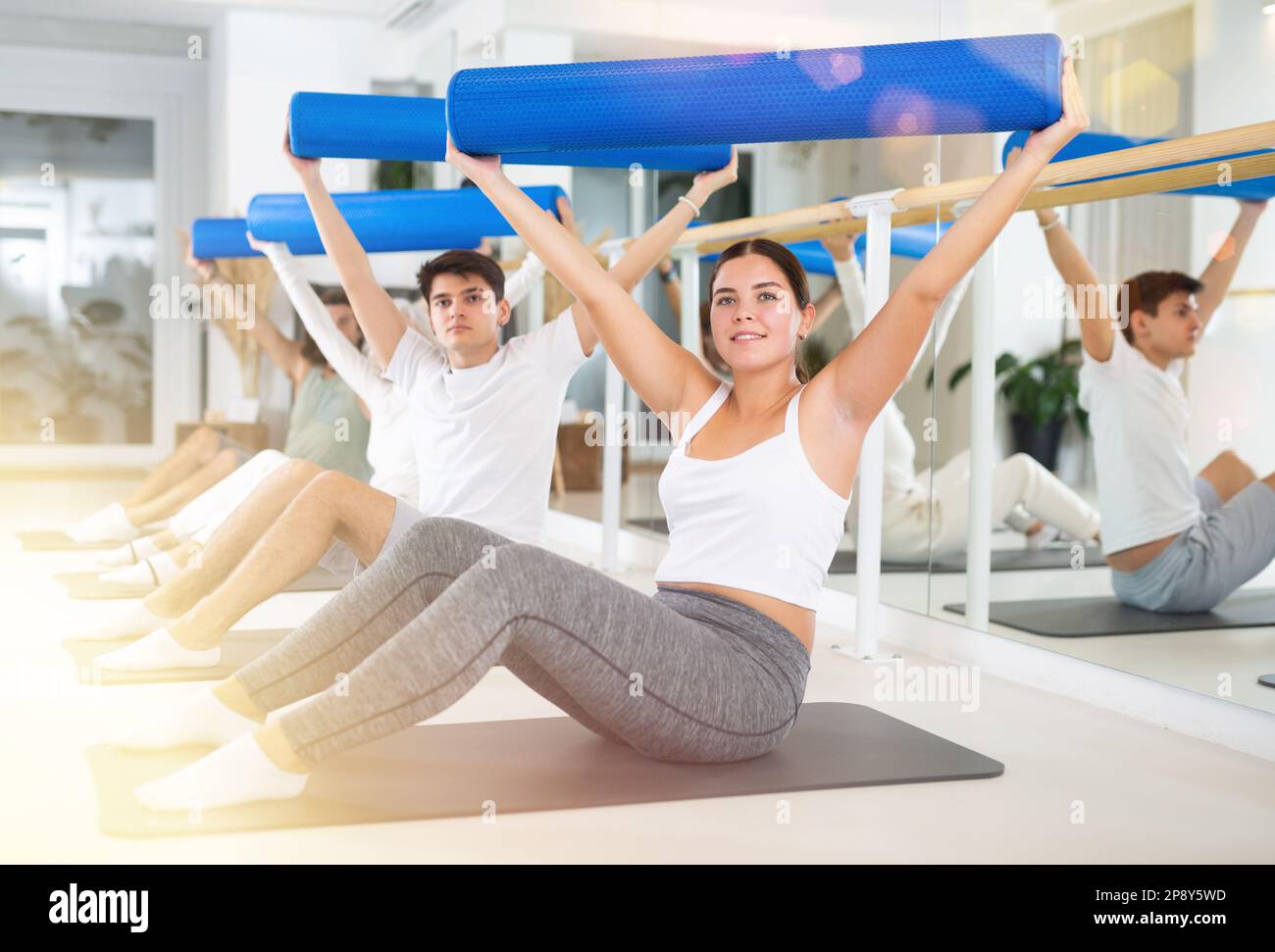 Young woman practicing pilates with roller in gym room Stock Photo - Alamy
