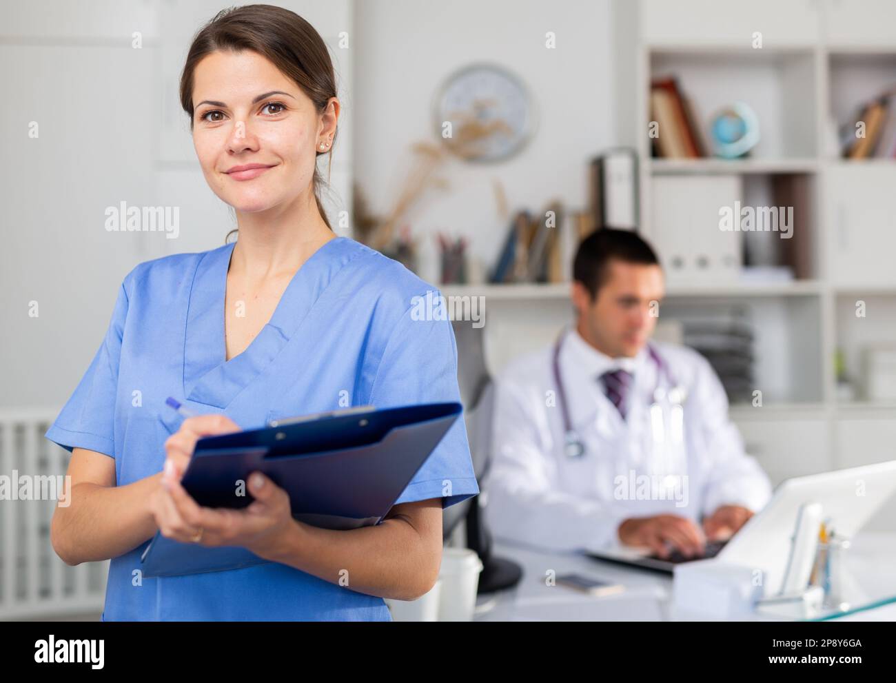 Positive nurse with folder of documents at office Stock Photo - Alamy