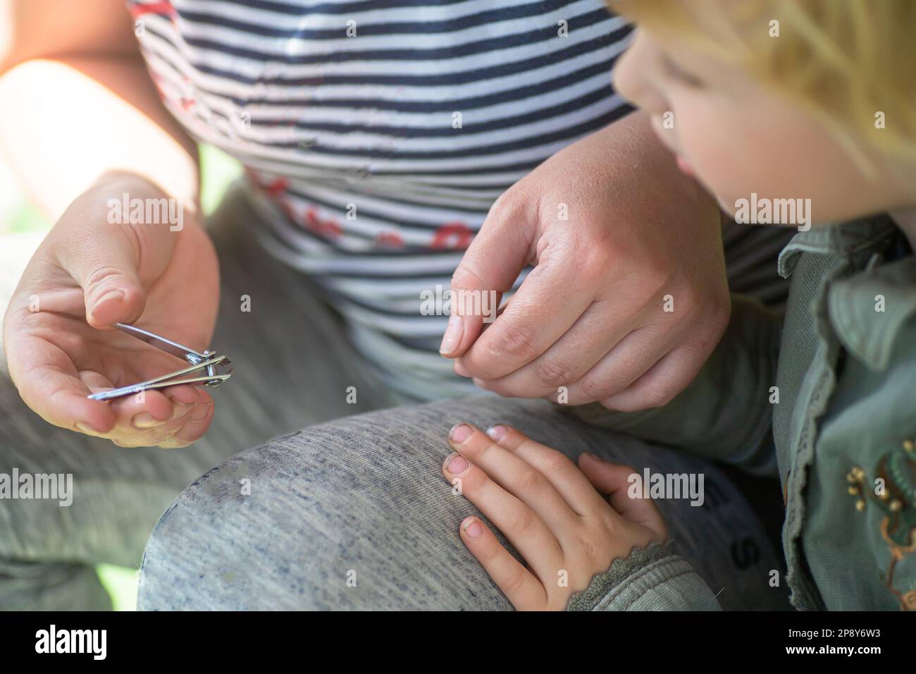 Mom cuts off the child's nails with tongs. Child care. Personal hygiene ...