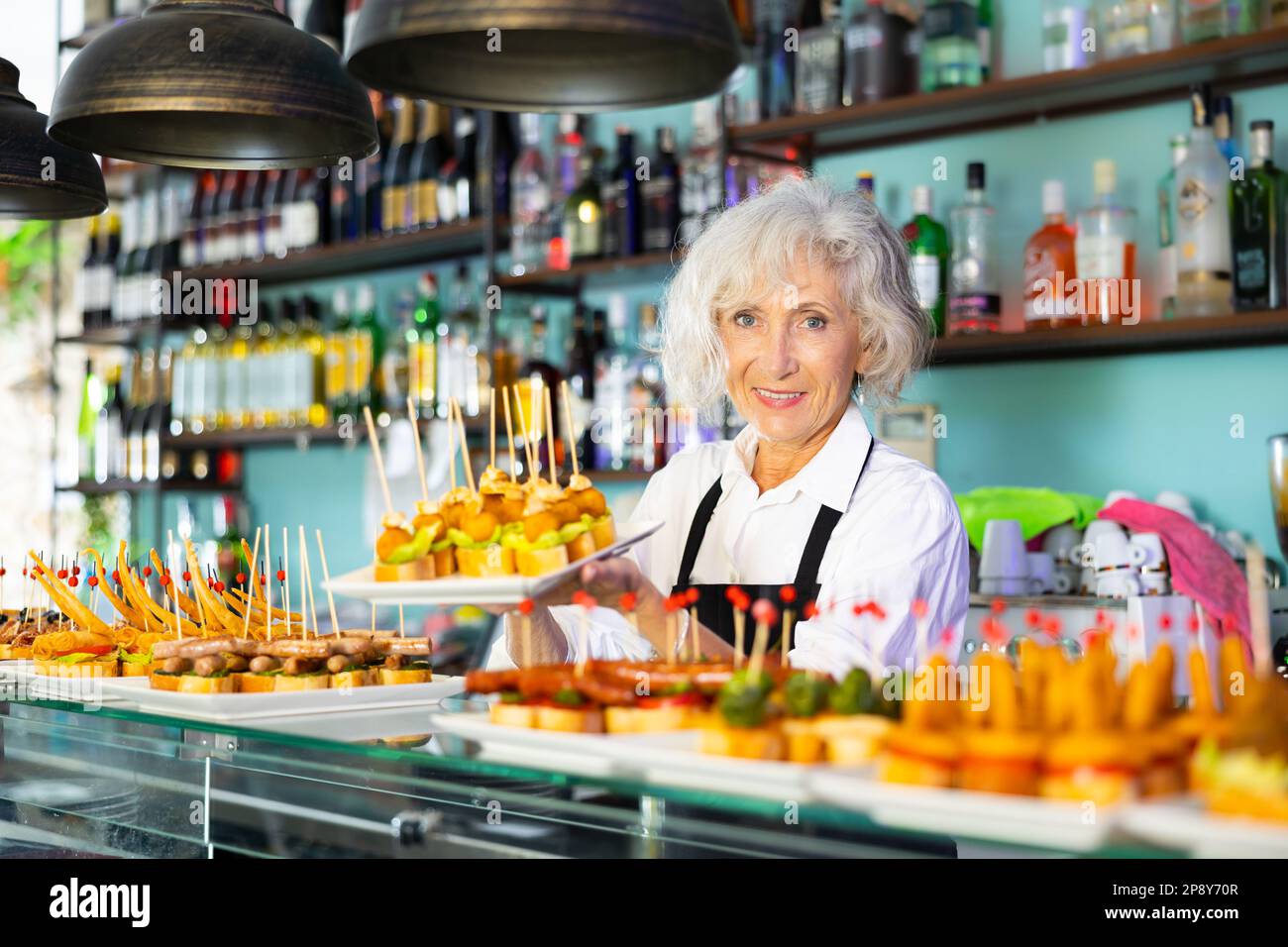 View on the elder European lady standing at the food display Stock ...