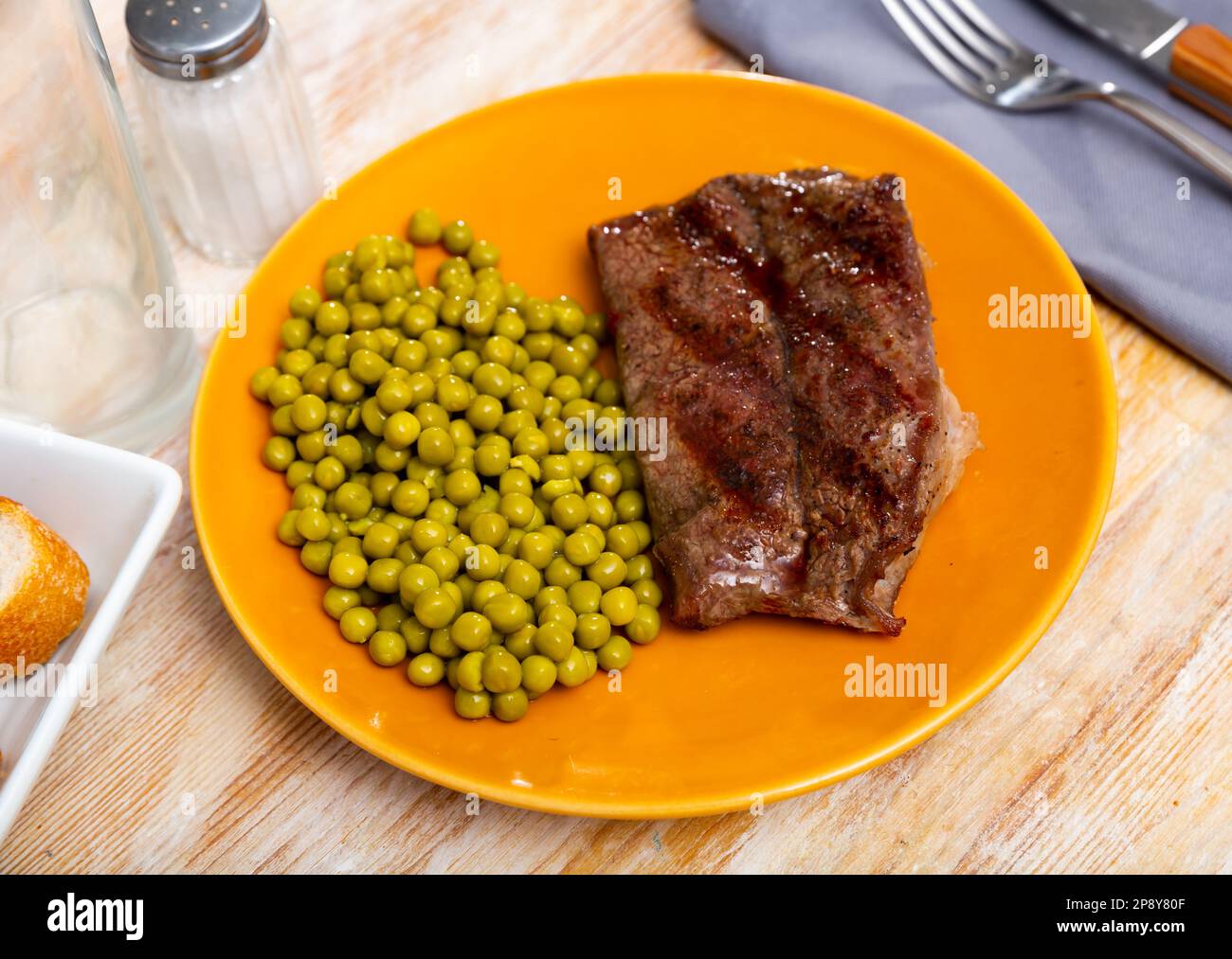 Fried beef cutlet with green peas on plate Stock Photo - Alamy