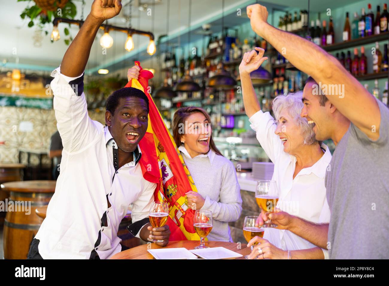 Happy fans celebrating the victory of Spanish team in bar Stock Photo ...