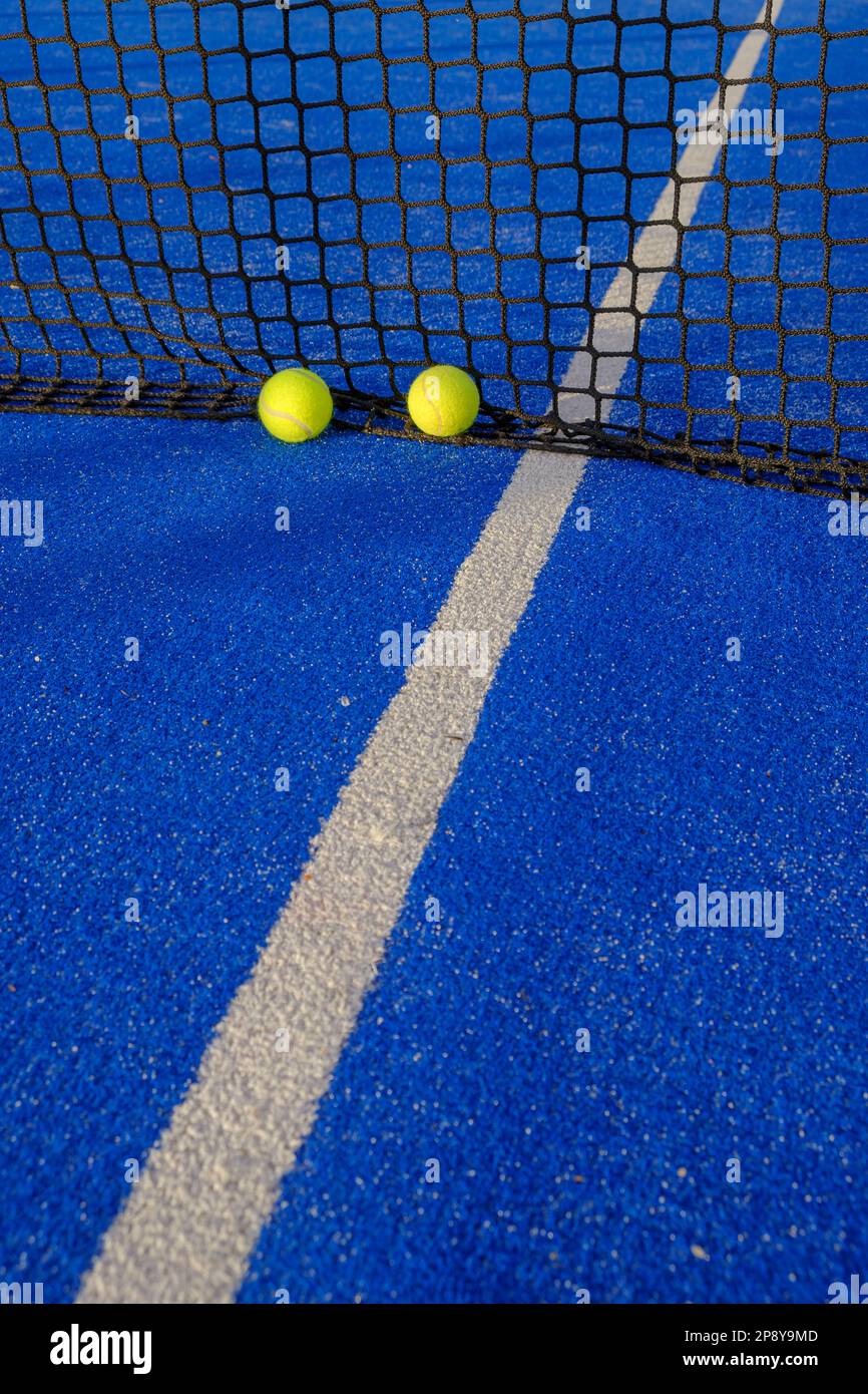 Two paddle tennis ball near the net of a blue court Stock Photo - Alamy