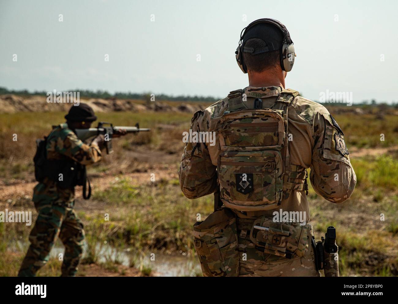 U.S. Marine Corps Marine observes the firing technique of a member of ...