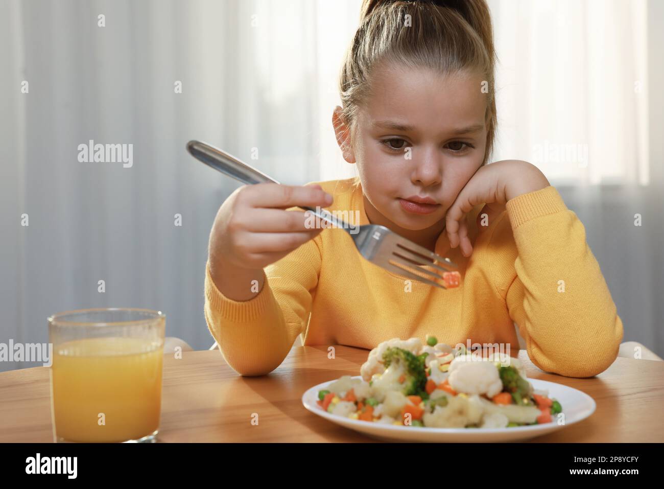 Cute little girl refusing to eat vegetable salad at home Stock Photo ...
