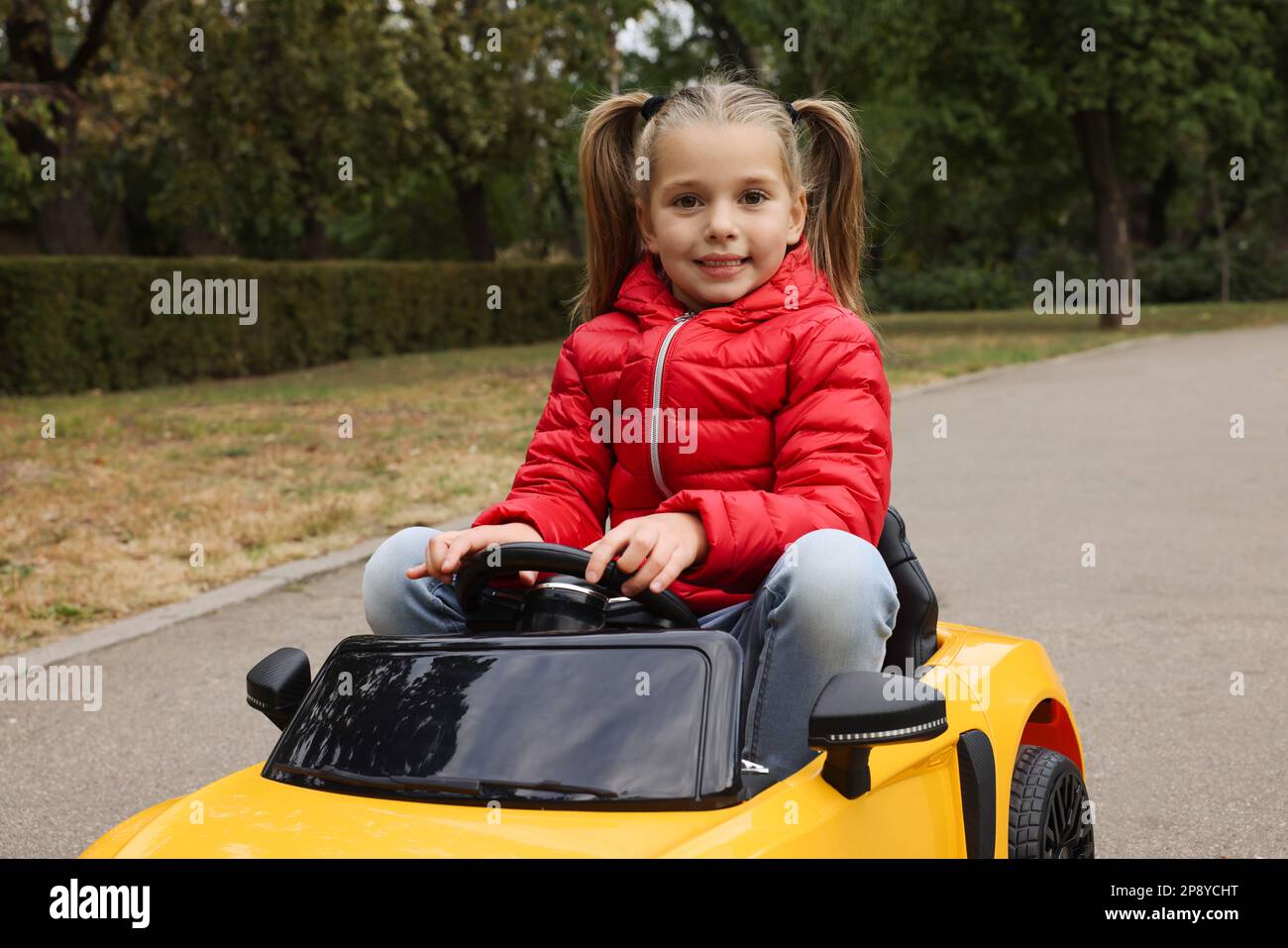 Cute little girl driving children's car outdoors Stock Photo - Alamy