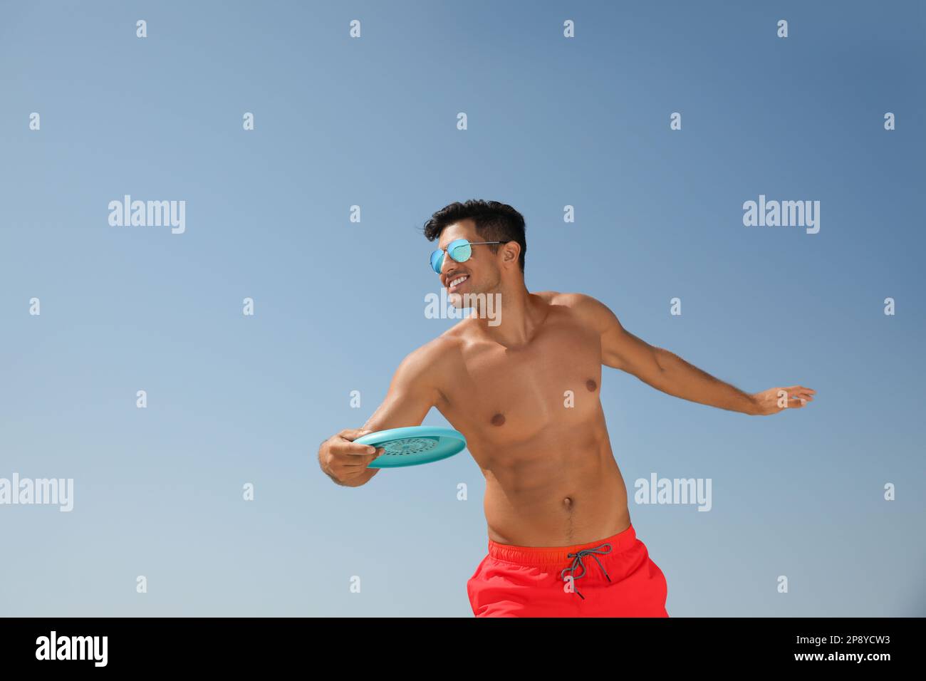 Happy man throwing flying disk against blue sky on sunny day Stock ...